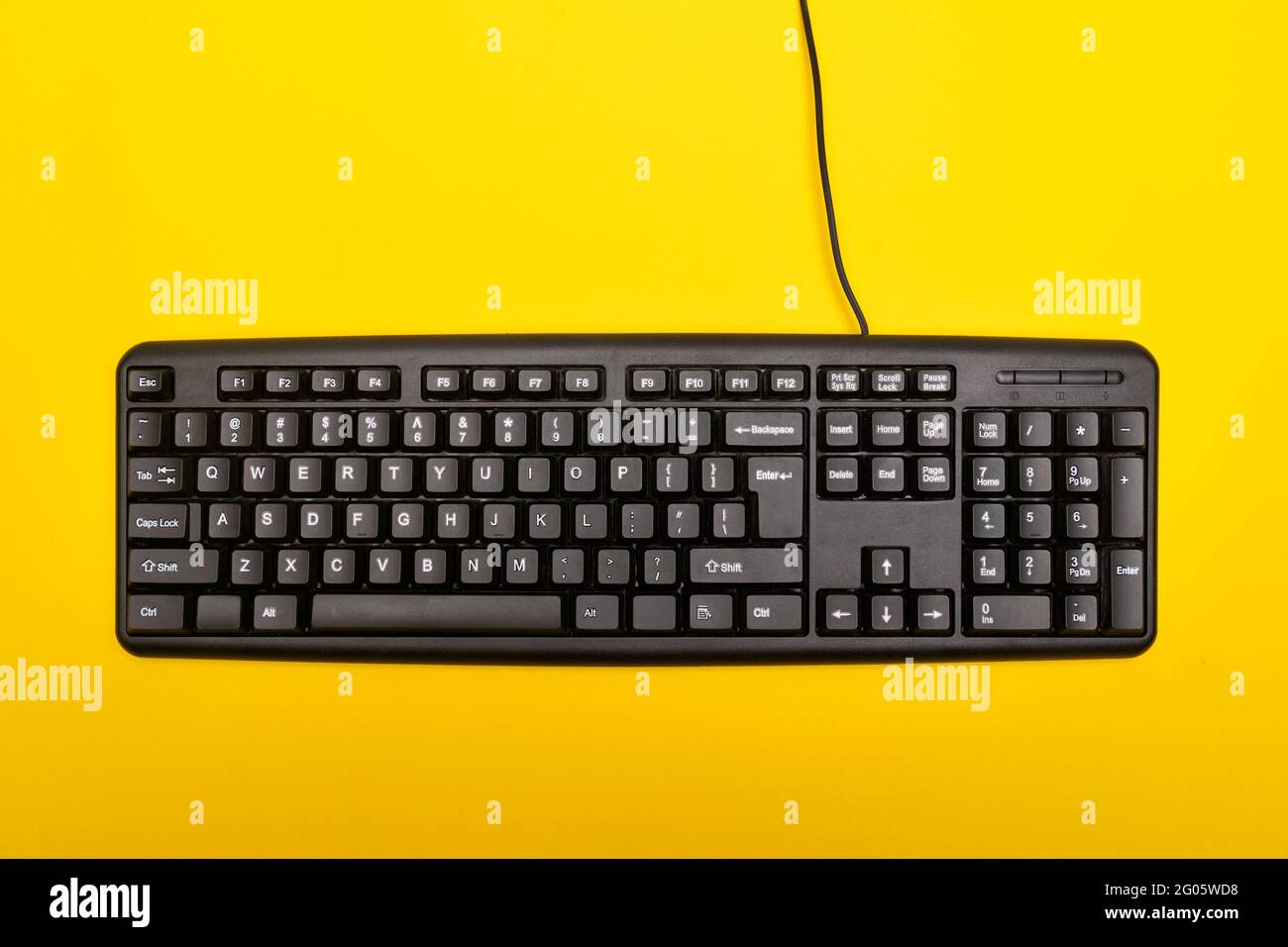 Black keyboard on bright yellow background. Wired computer keyboard ...