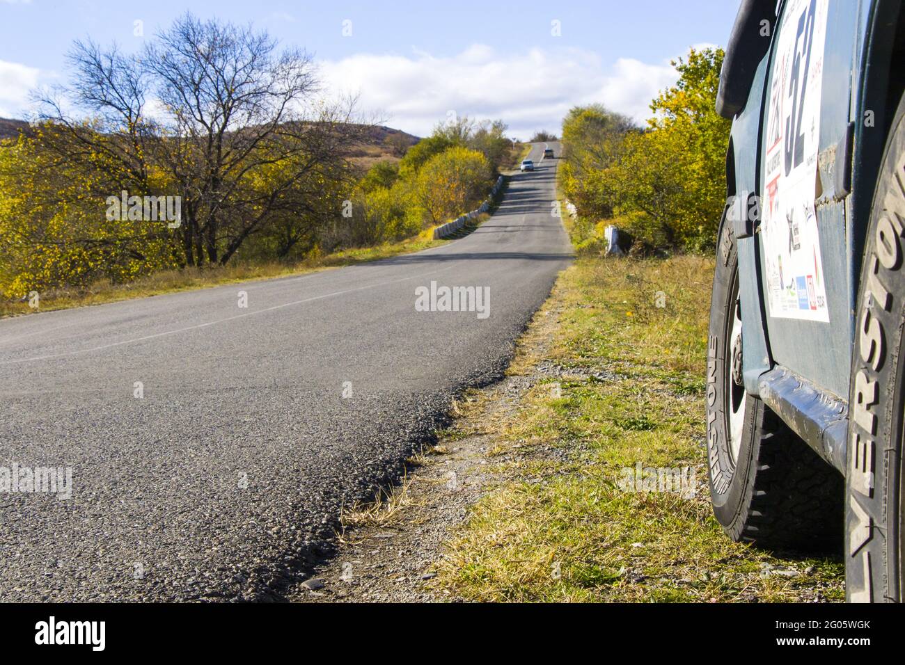 Car on the road, highway, autumn tree, plants and blue cloudy sky Stock ...