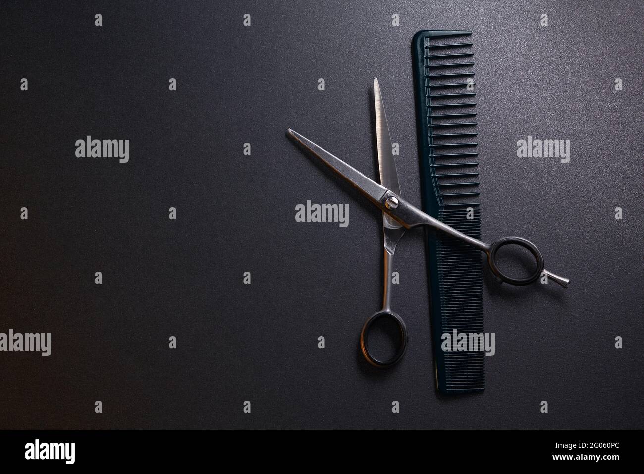 professional hairdressers scissors and comb on black background. Beauty ...