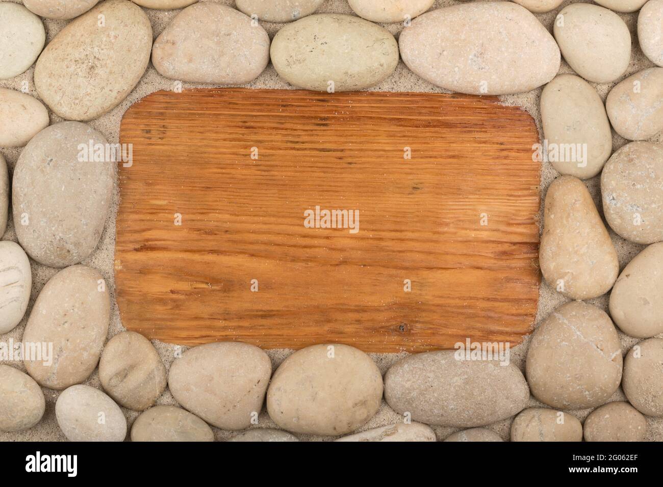 Wooden sign lies on the sand among the stones. Empty place. Top view ...