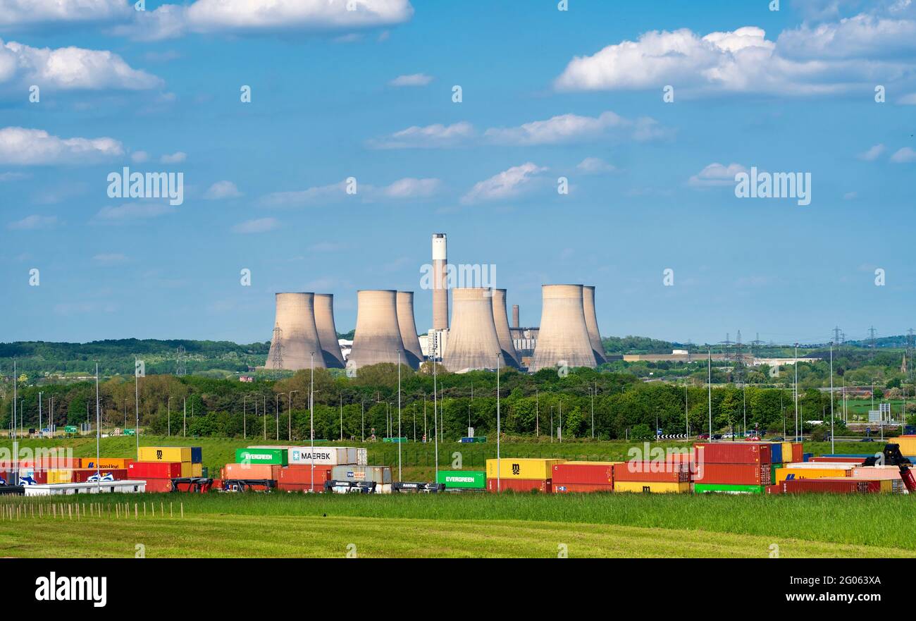 Shipping containers in a rail depot with distant power station behind ...