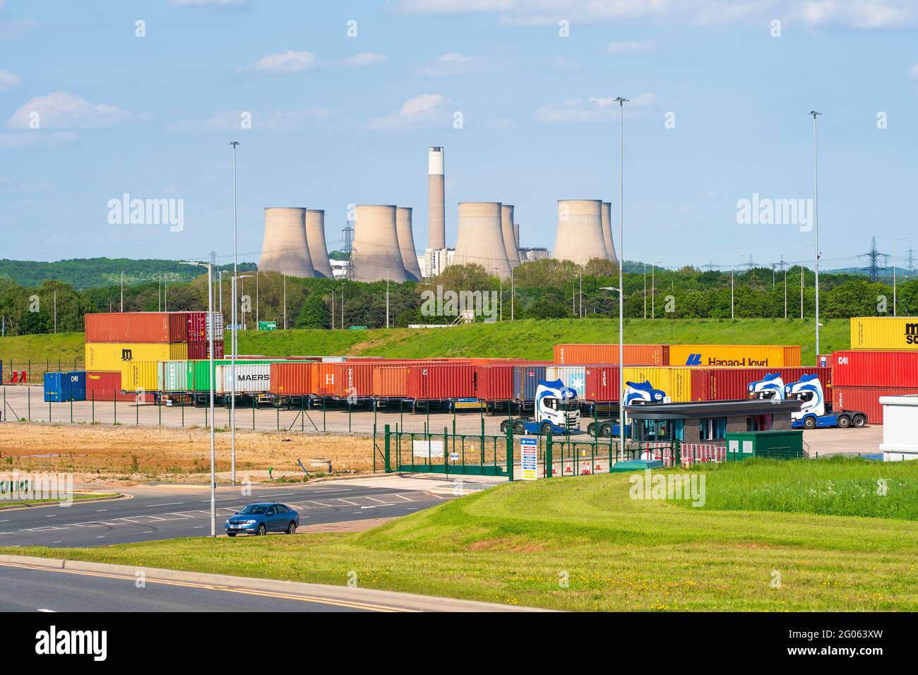 Shipping containers in a rail depot with distant power station behind ...