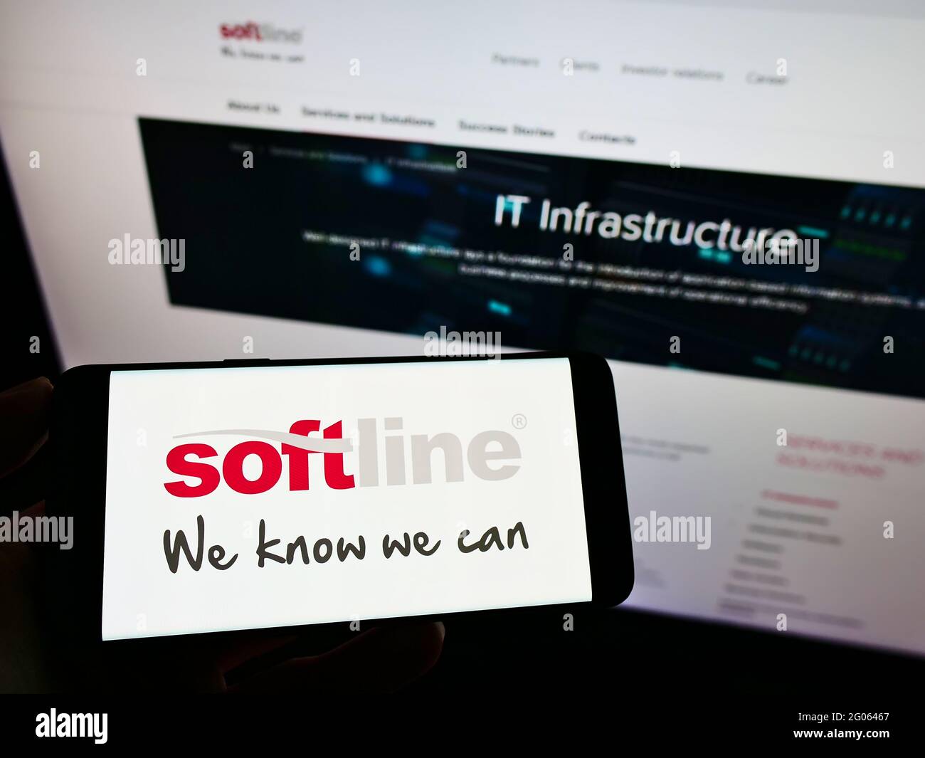 Person holding mobile phone with logo of global IT solutions provider ...