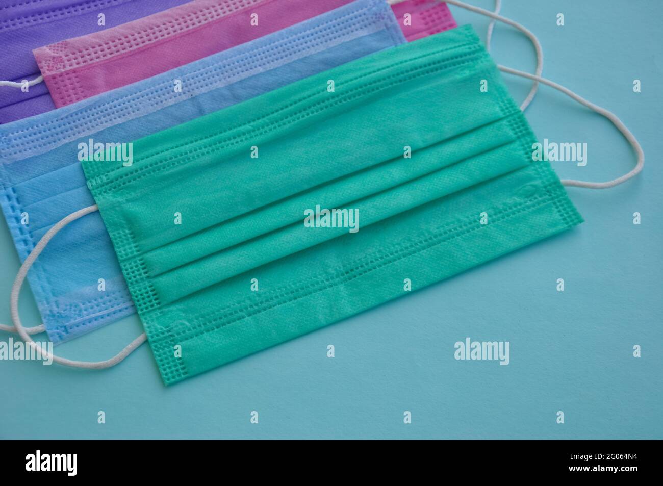 High angle shot of multicolored medical face mask isolated over blue ...