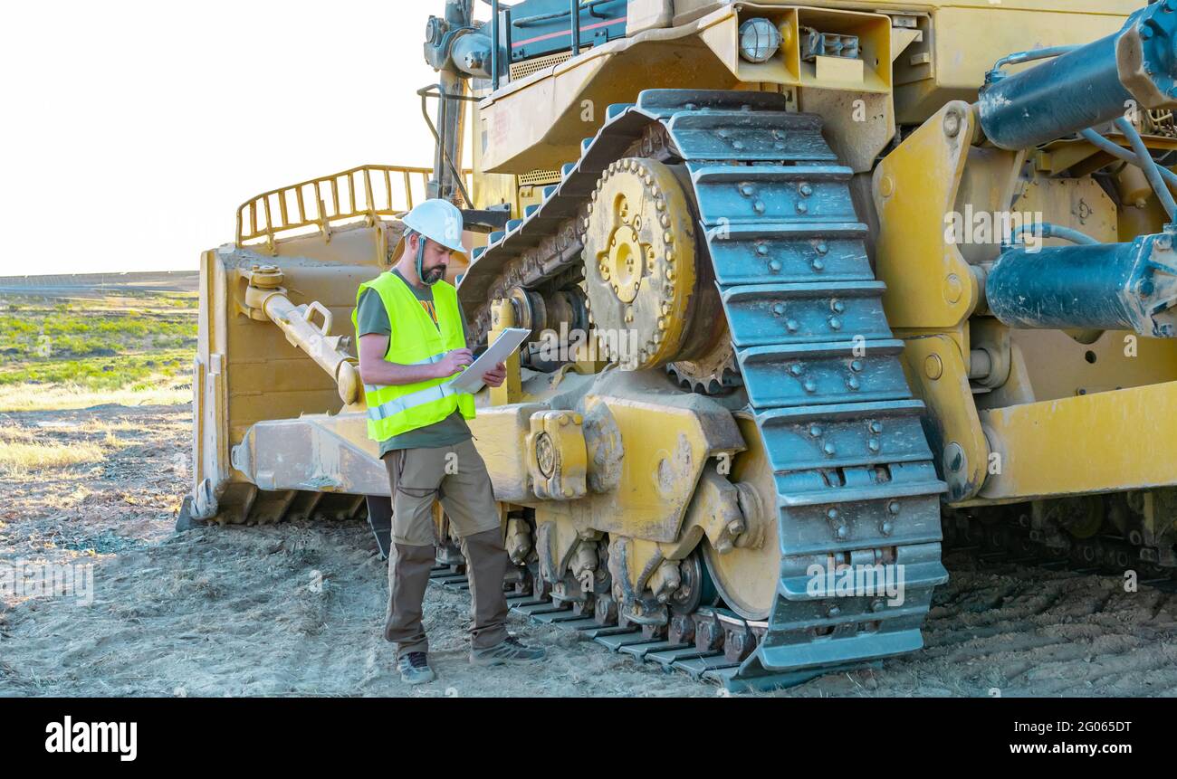 maintenance manager taking notes on an inspection of a heavy road ...