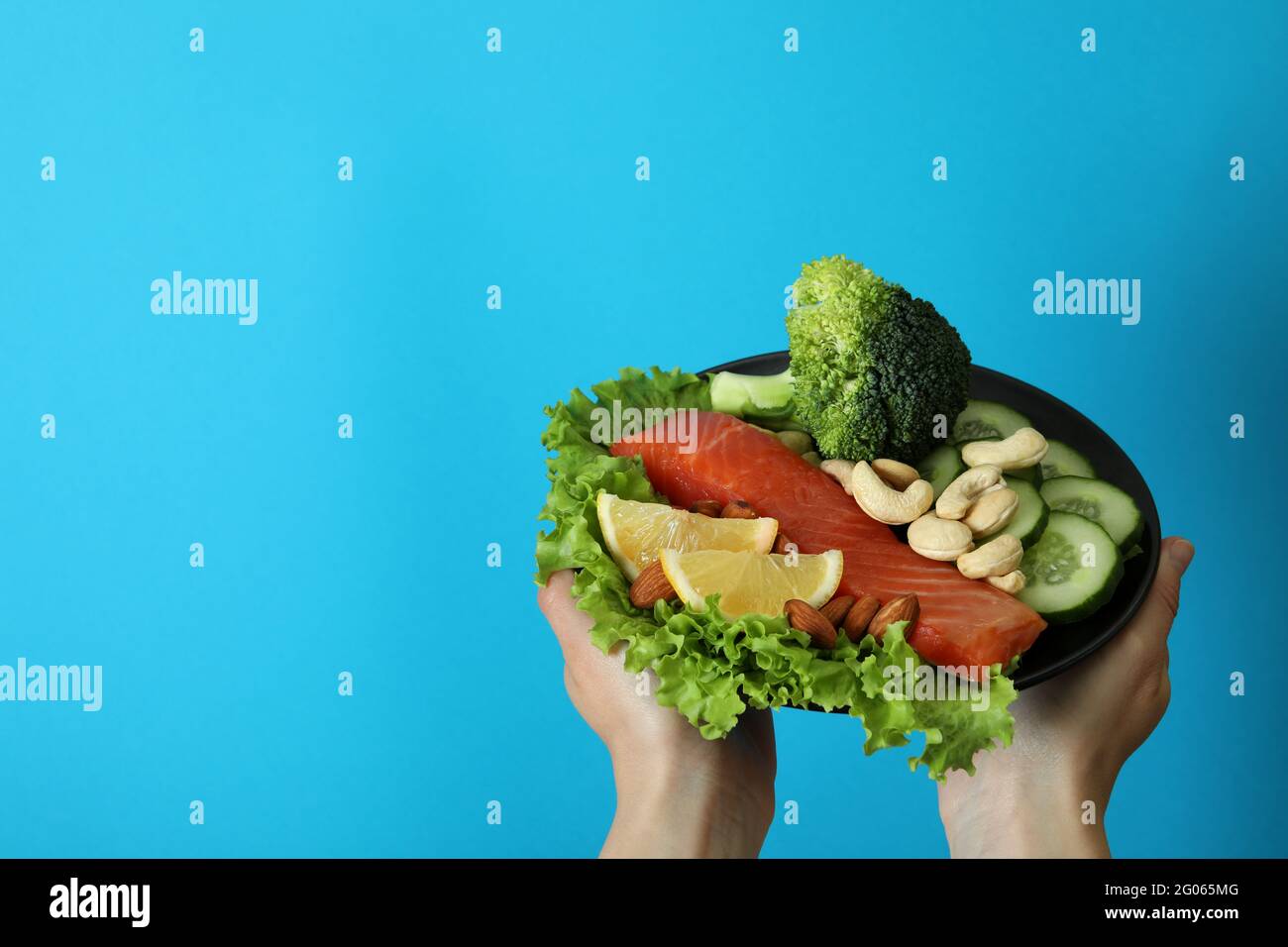 Female hands hold healthy food on blue background Stock Photo - Alamy