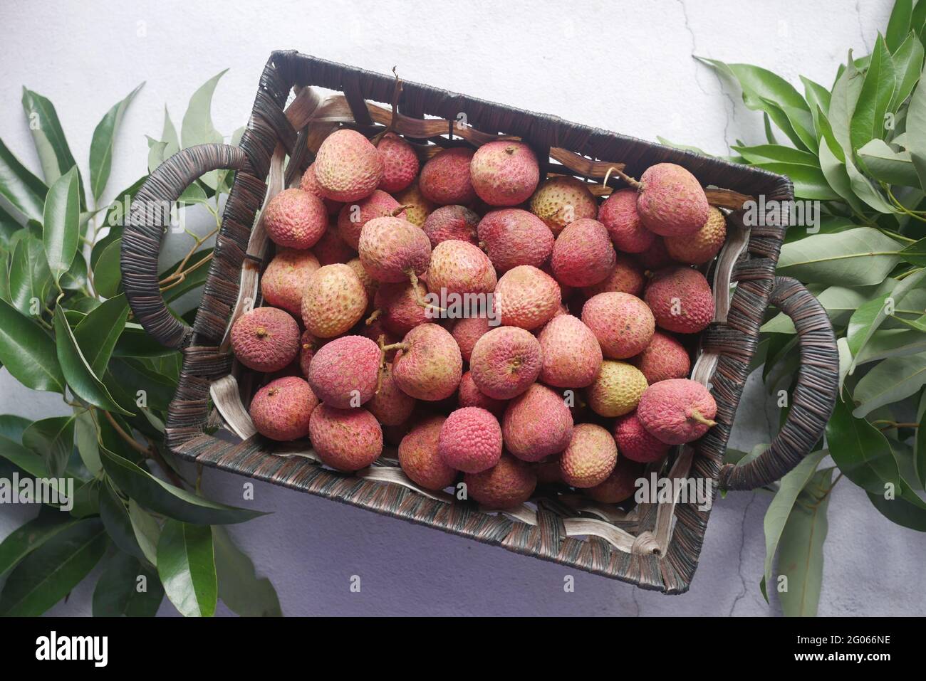 Lychee and leafs in a box on wooden background top down Stock Photo - Alamy
