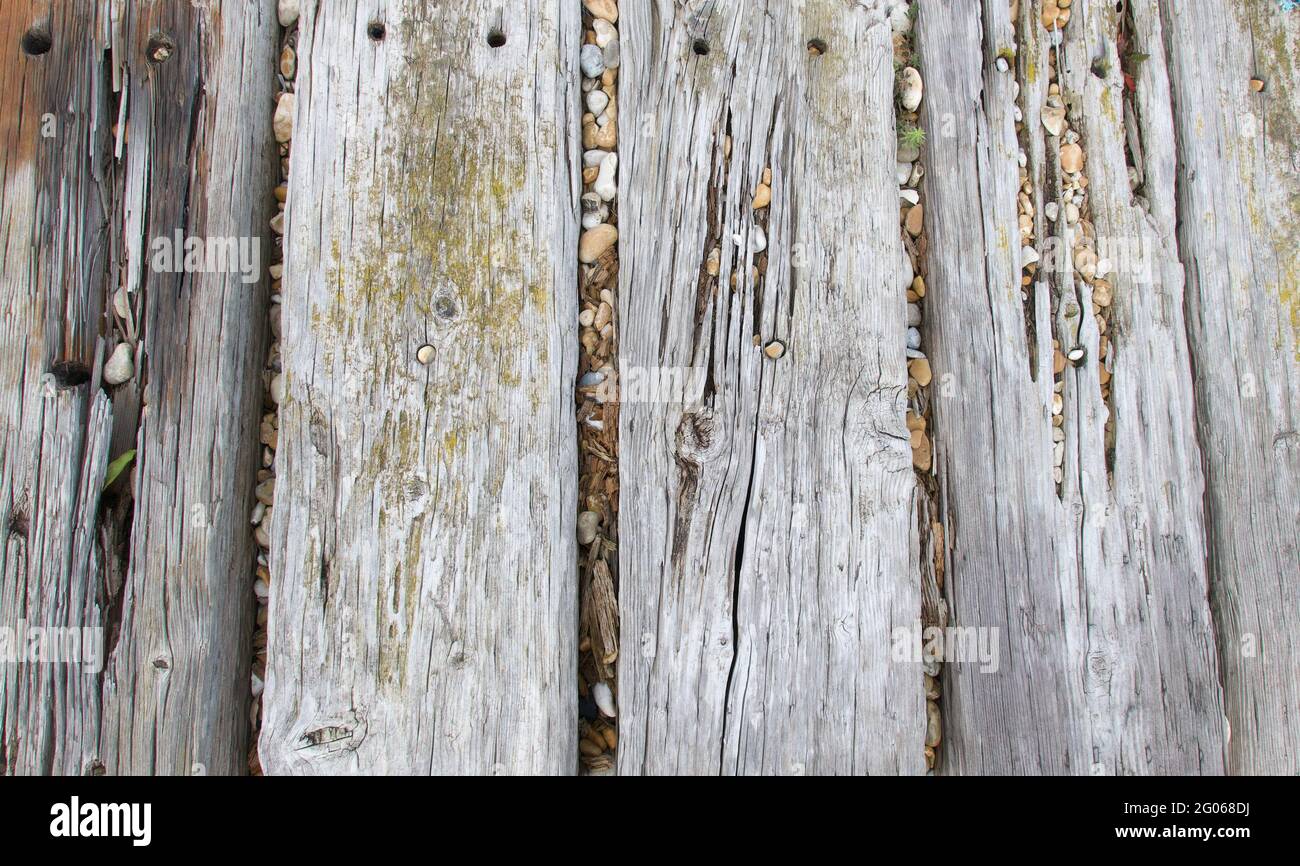 Old weathered planks of wooden path with stones in gaps Stock Photo - Alamy