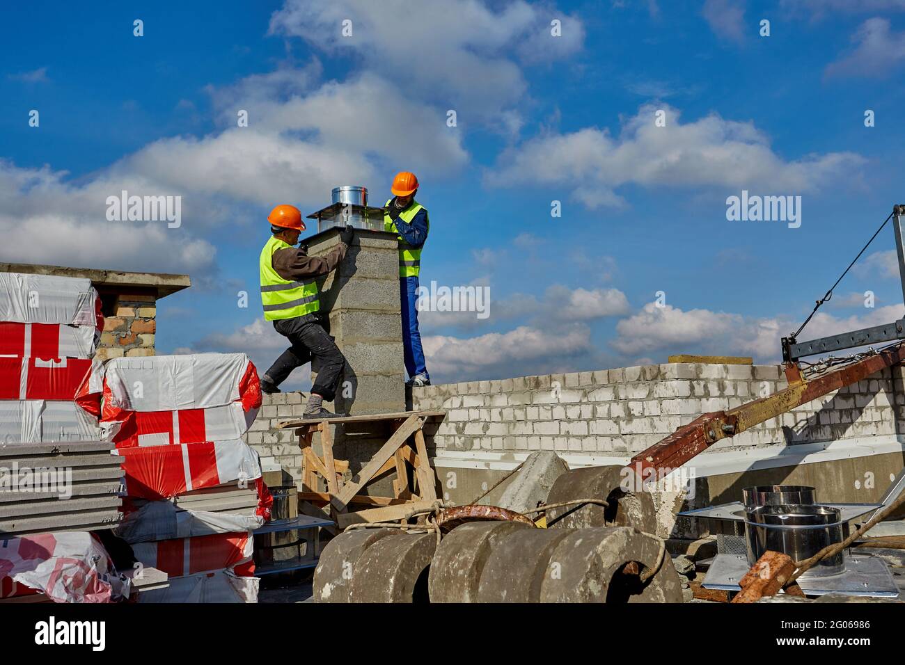 Two workers in safety helmets are working with ventilation system on ...