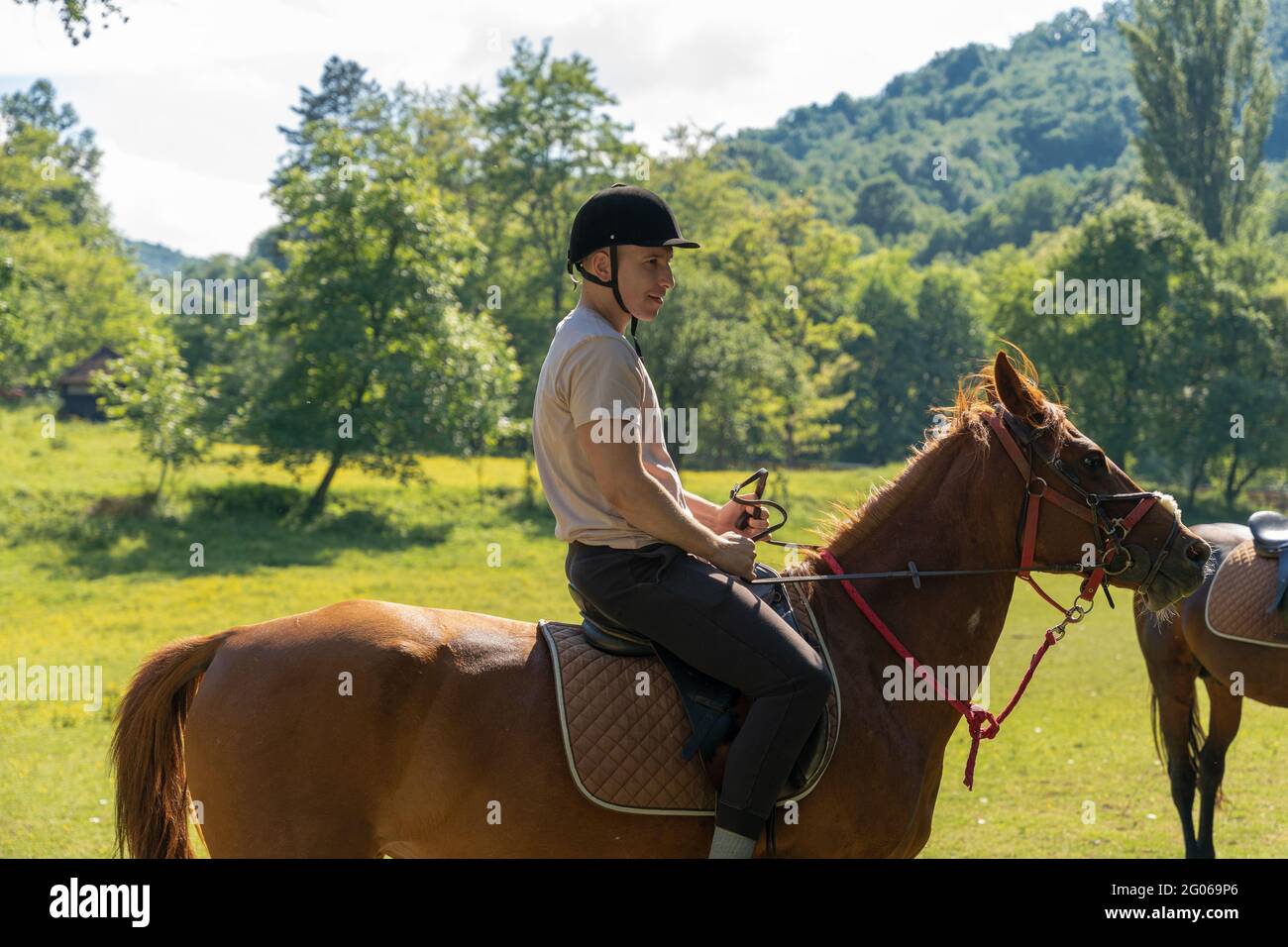 A young muscular jockey on his horse Stock Photo - Alamy