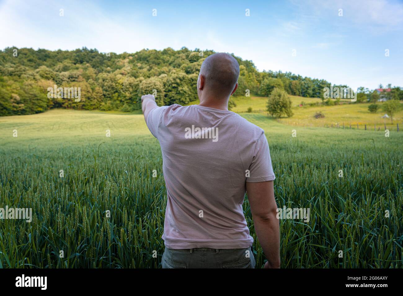 Young farmer pointing at something in the distance Stock Photo - Alamy