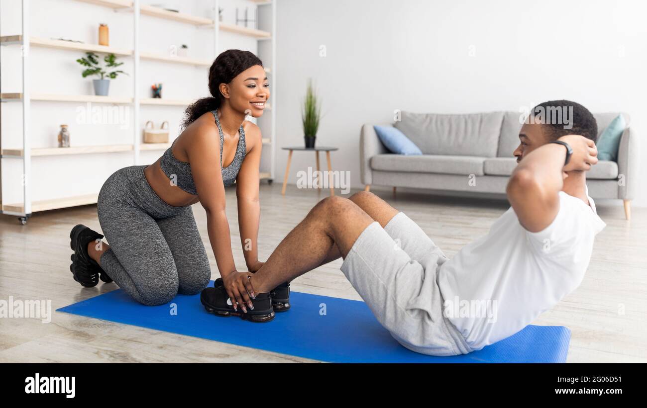 Cool black guy doing core exercises with his girlfriend, working out as ...