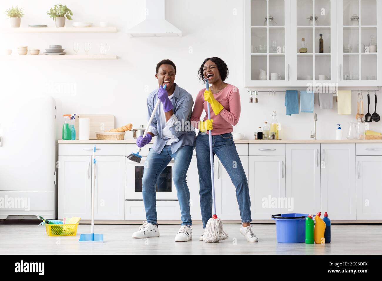 Joyful african american family having fun while cleaning kitchen ...