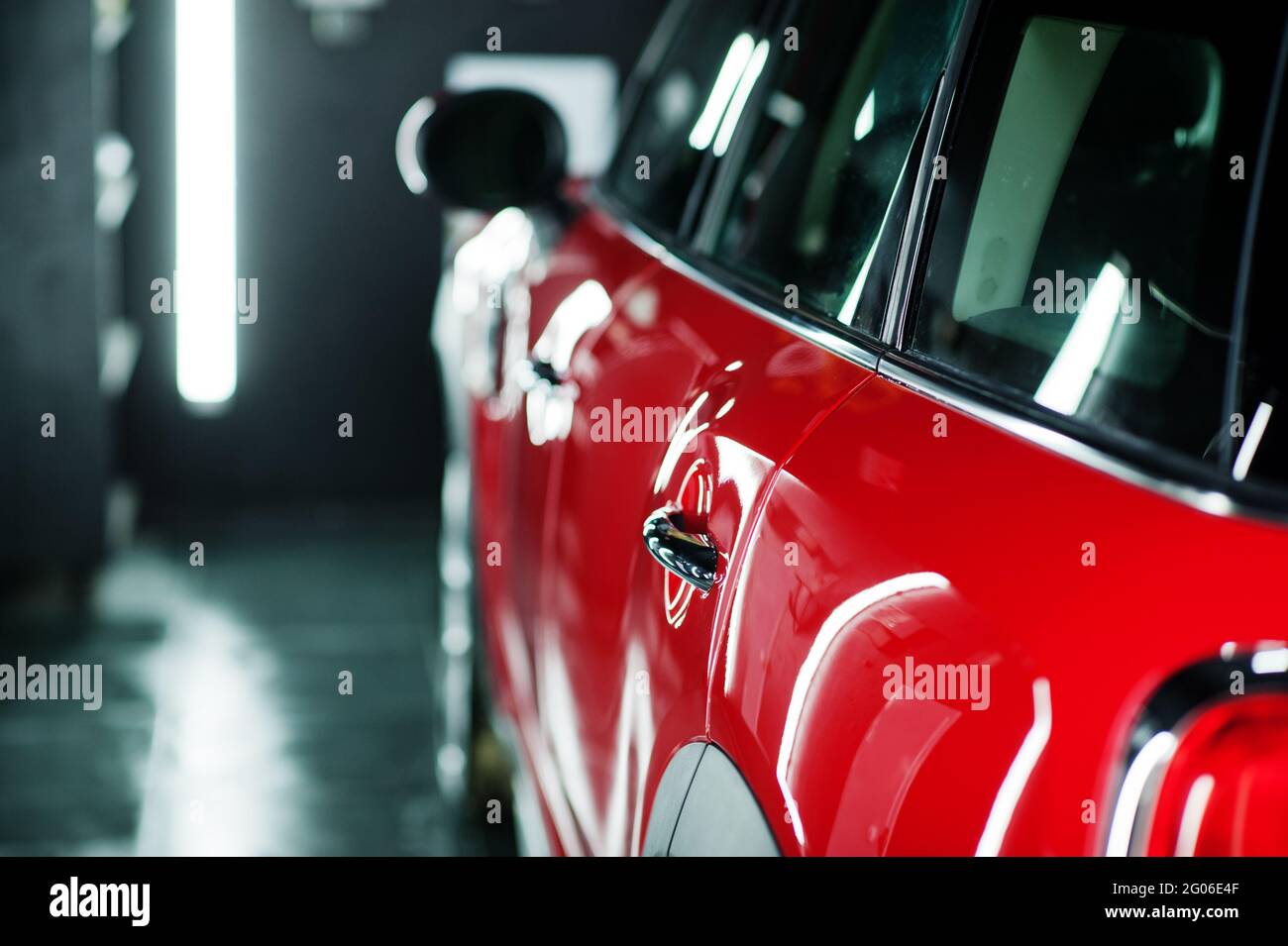 Red polished car in professional detailing garage Stock Photo - Alamy