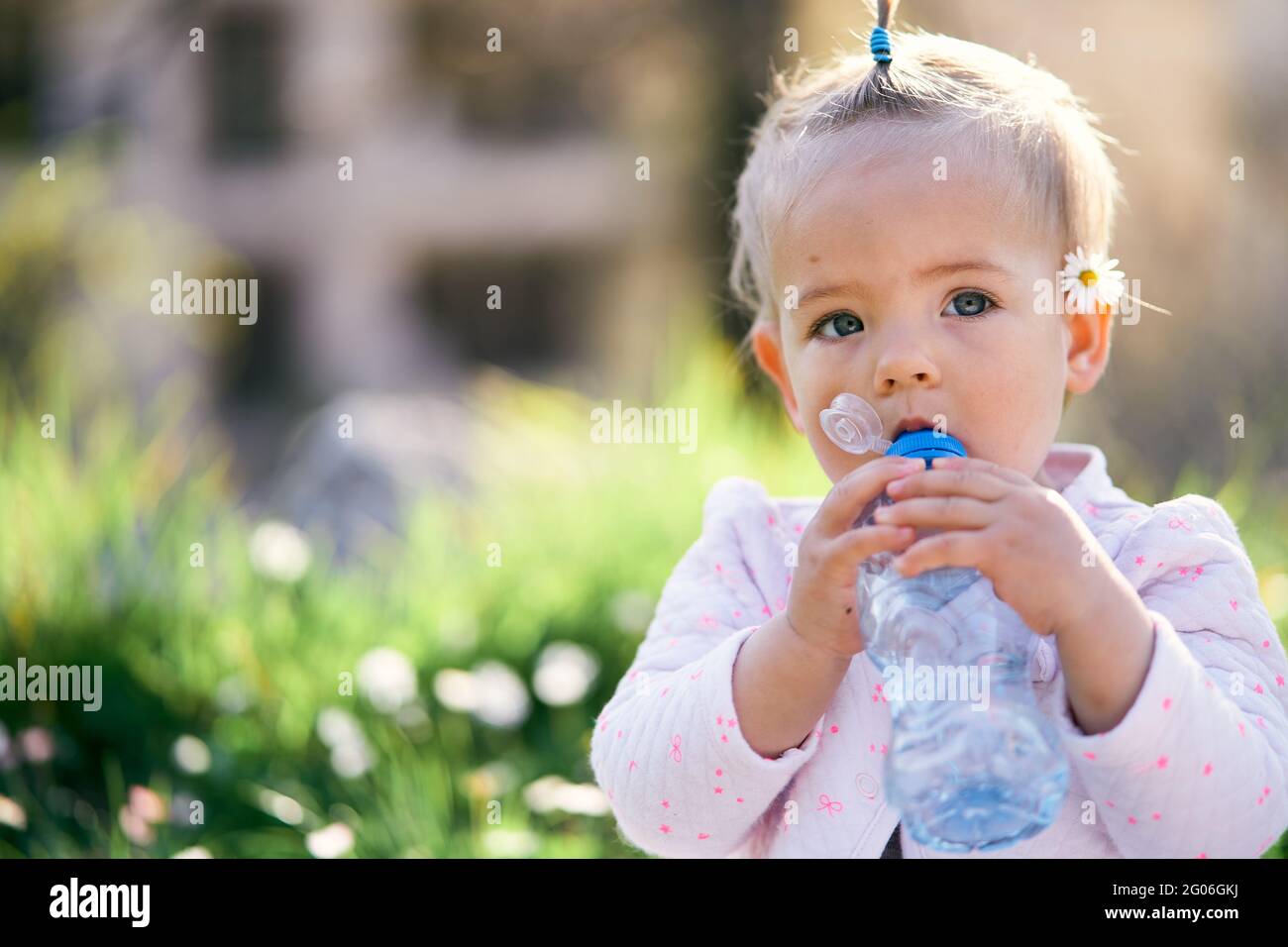 Small child drinks from a plastic bottle. Close-up Stock Photo - Alamy