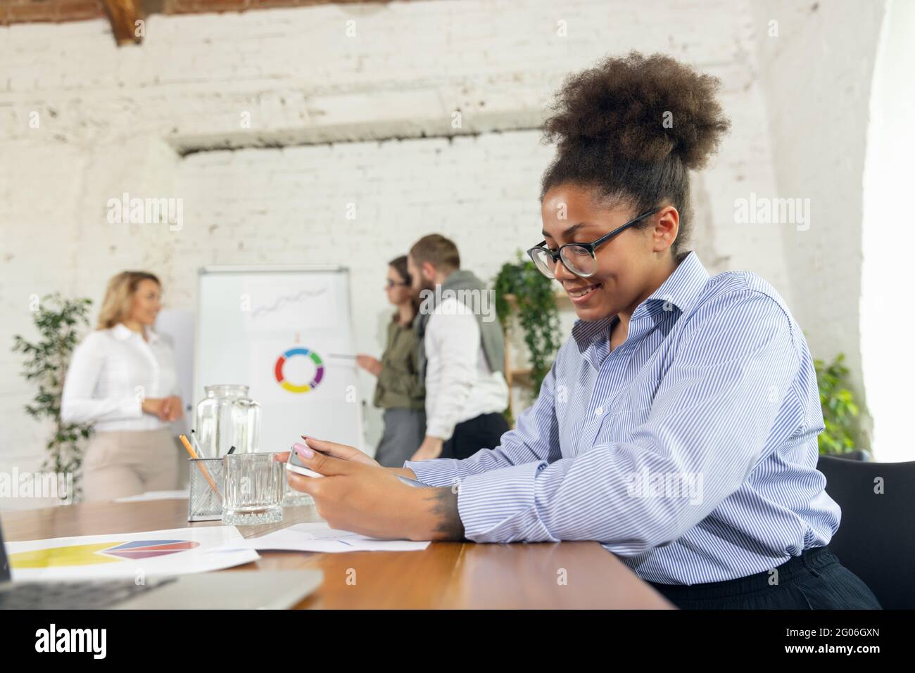 Young African woman at modern office with colleagues. Concept of ...
