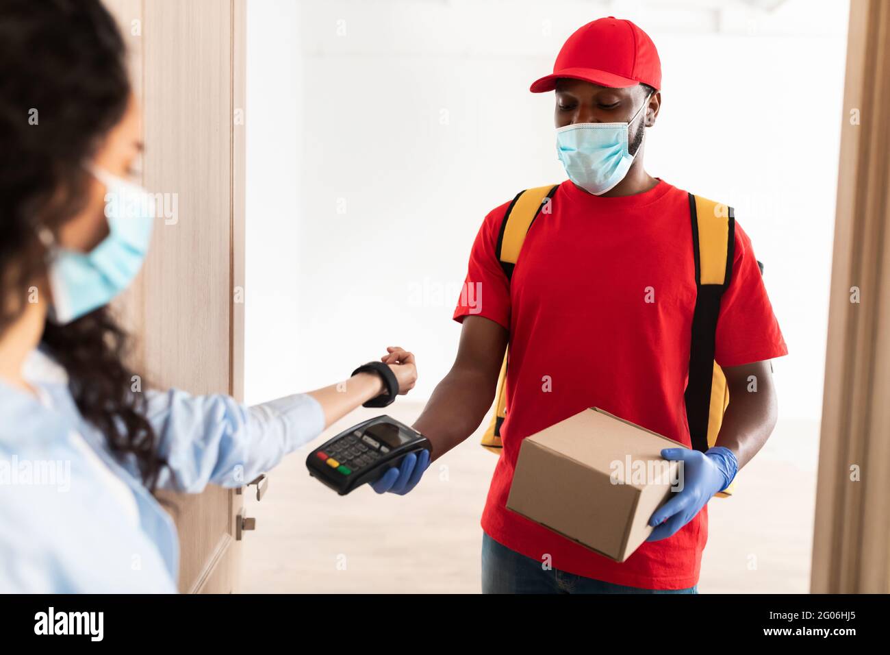 Black man holding POS machine client paying with smart watch Stock ...
