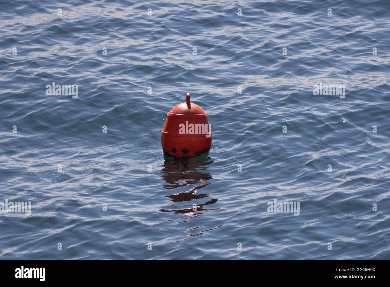 Red buoy floating in blue waters Stock Photo - Alamy