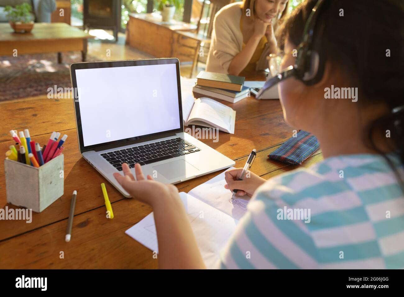 Asian girl using laptop with blank screen, writing, learning online her ...