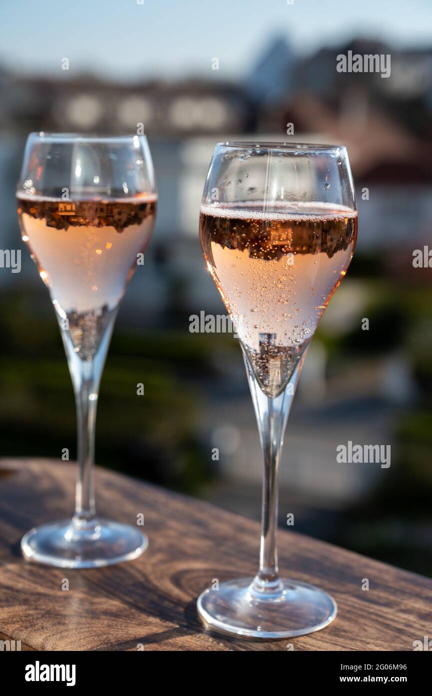 Drinking of rose champagne sparkling wine from flute glasses on outdoor ...