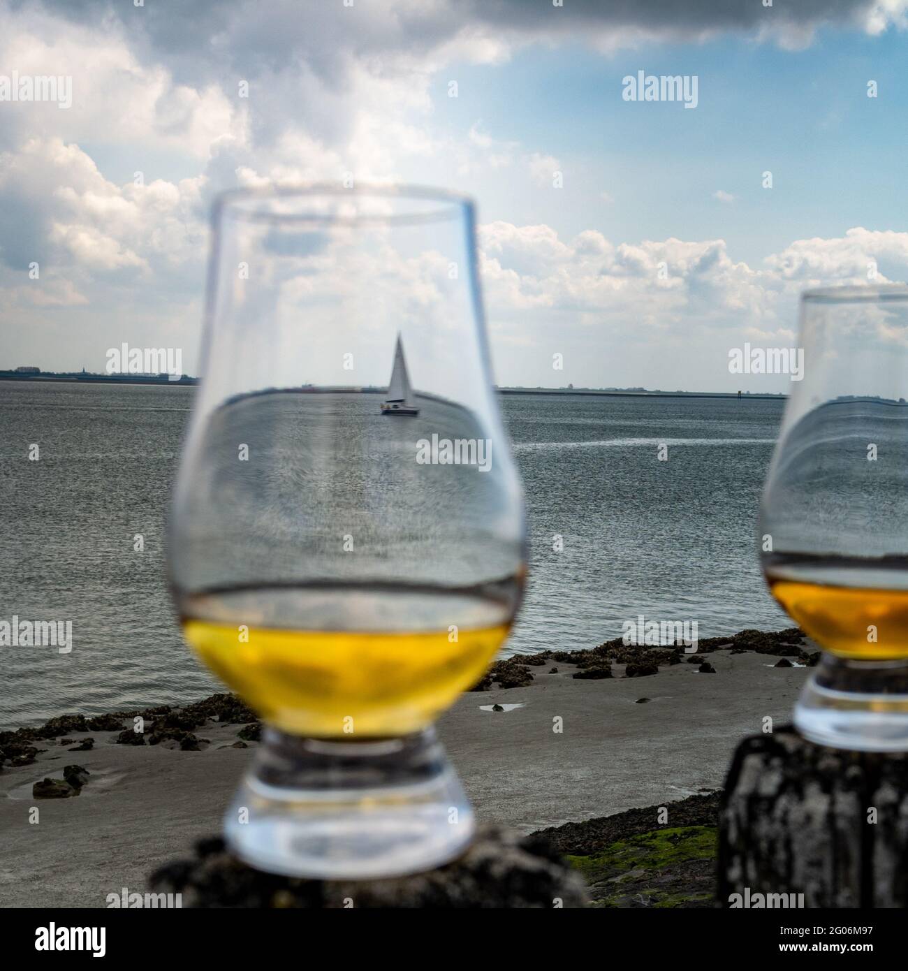 Tasting of dram single malt scotch whisky on seashore in Scotland, old ...