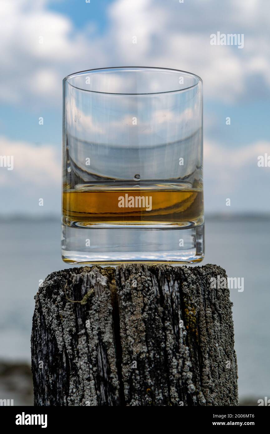 Tasting of dram single malt scotch whisky on seashore in Scotland, old ...