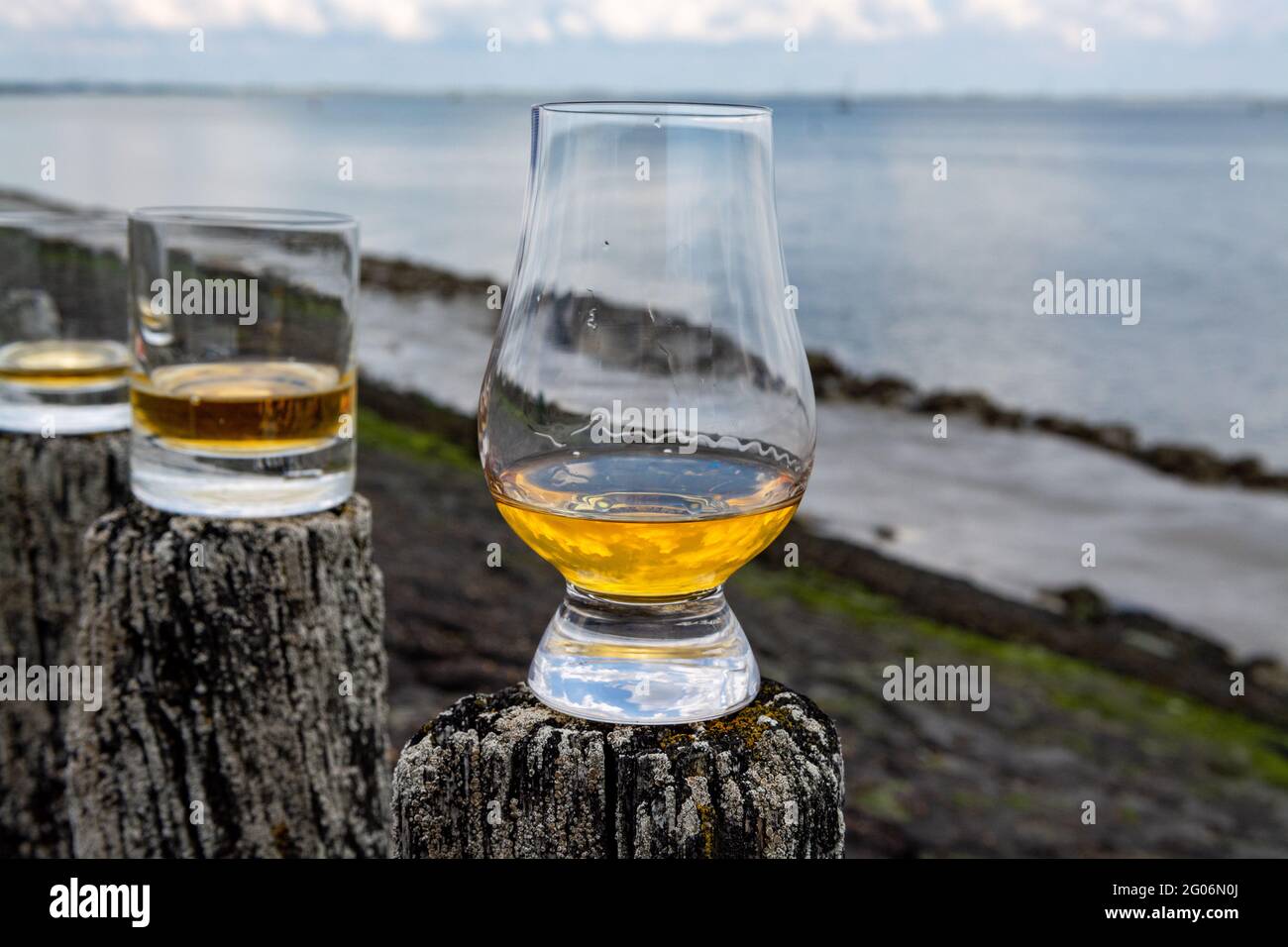Tasting of dram single malt scotch whisky on seashore in Scotland, old ...