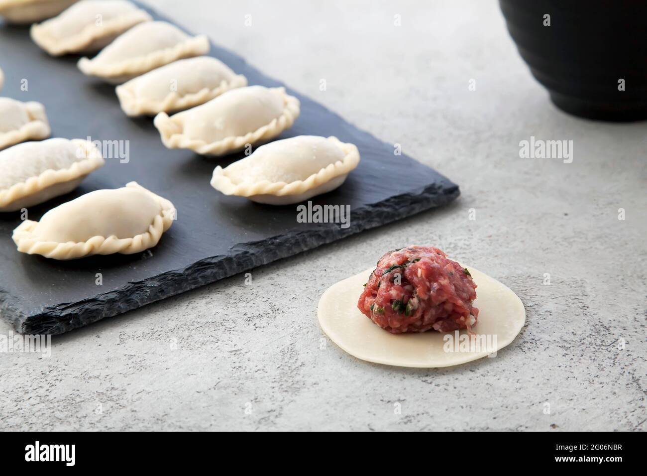 The finished dumplings are laid out on a black slate stone board, lying ...