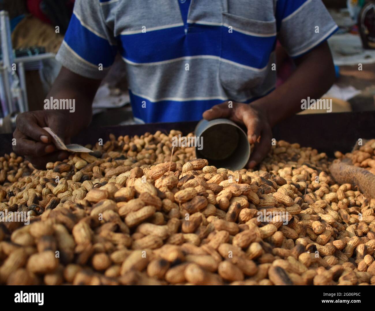 Street vendor selling groundnuts with traditionally measuring jar in ...