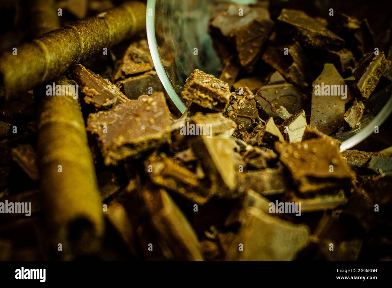 Chocolate chunks spilling out of a glass container and onto a surface ...