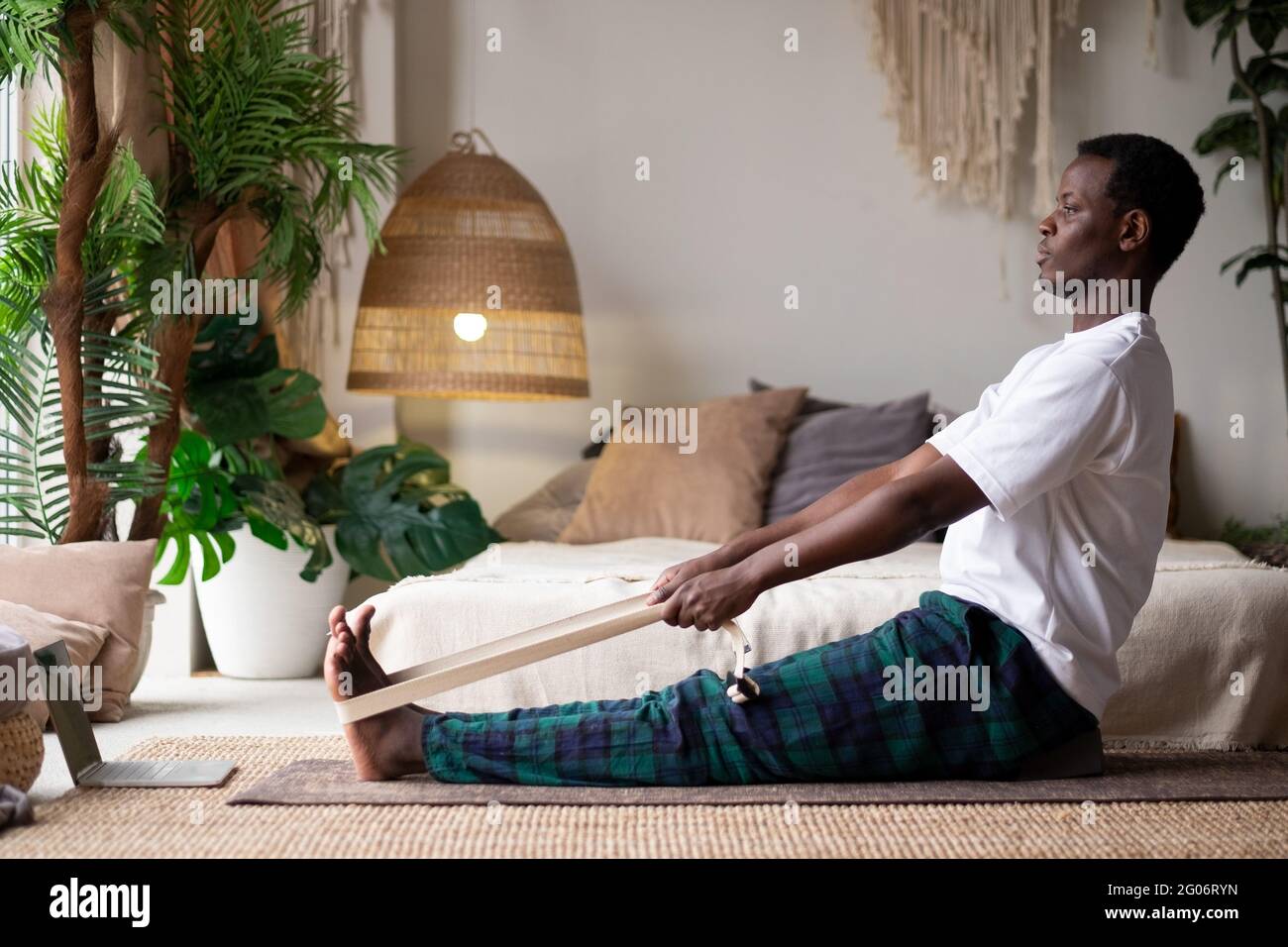 African young man sitting in paschimottanasana or Intense Dorsal ...