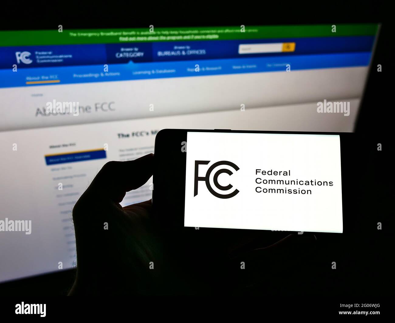 Person holding smartphone with seal of US agency Federal Communications ...