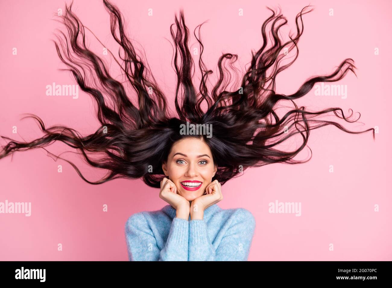 Portrait of pretty positive girl arms on cheeks hair flying toothy ...