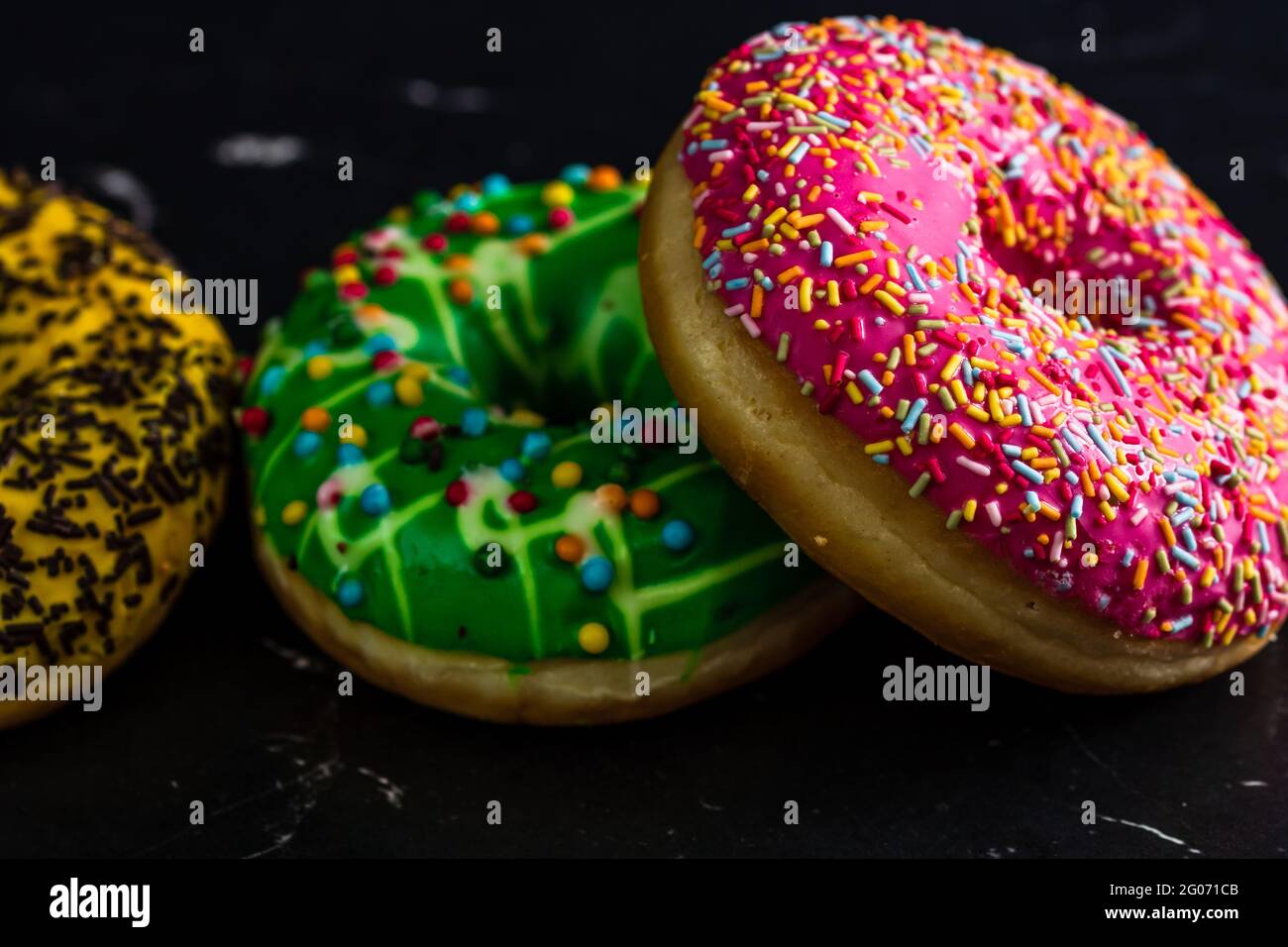 Glazed donuts with sprinkles isolated. Close up of colorful donuts ...