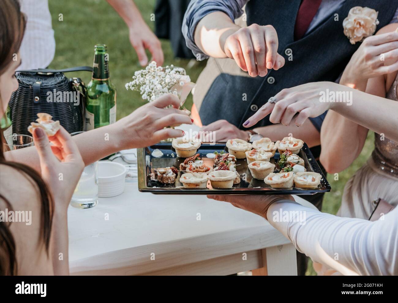 Close-up cropped image of waiter holding tray with finger food at ...