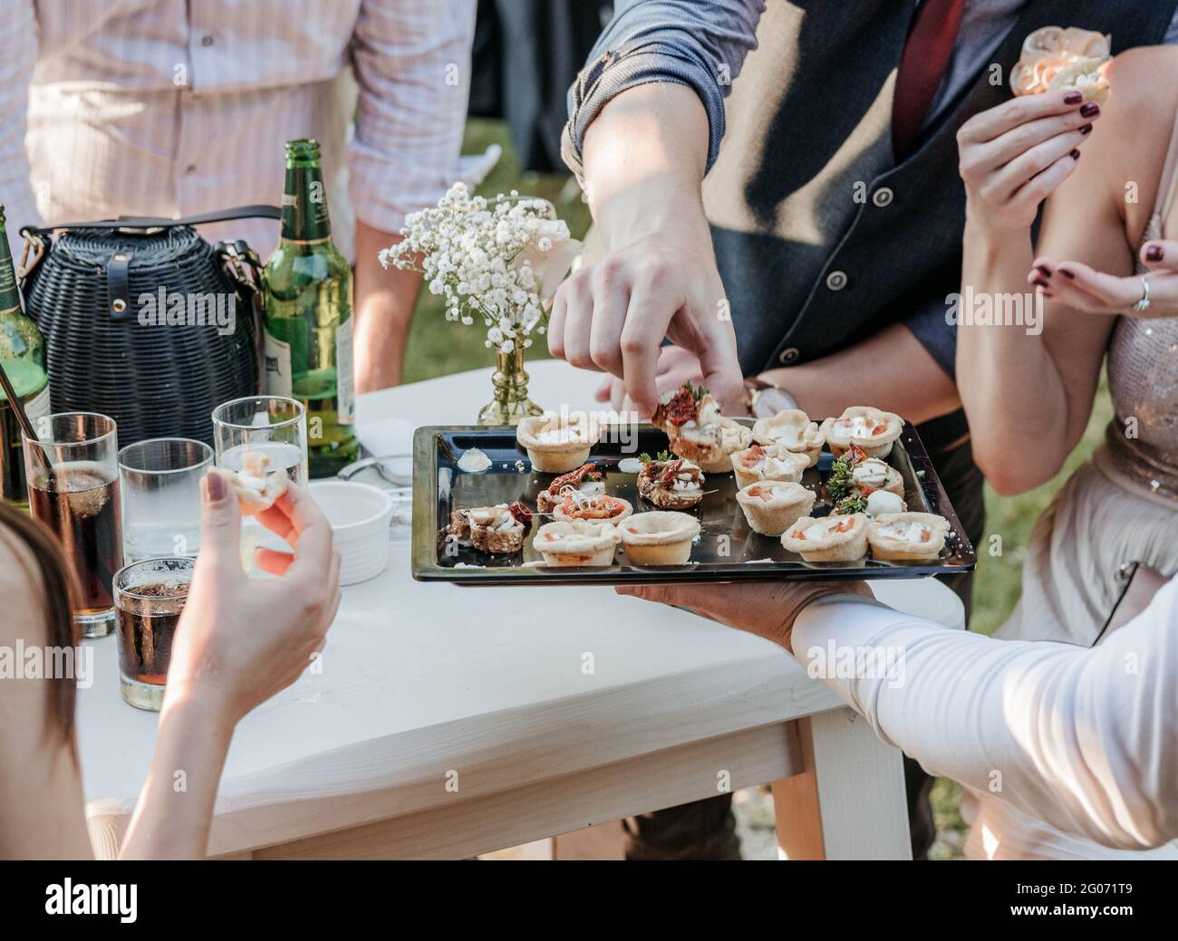 Close-up cropped image of waiter holding tray with finger food at ...