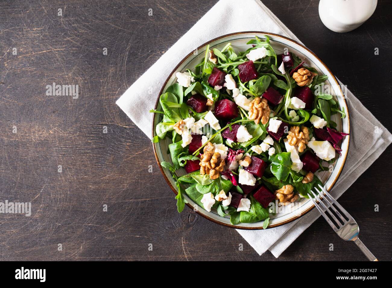 Beet or beetroot salad with fresh arugula, soft cheese and walnuts on ...