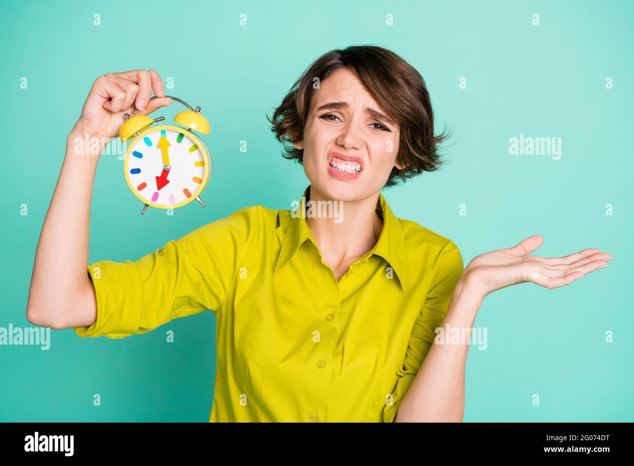 Photo portrait of grumpy female worker showing alarm clock deadline is ...
