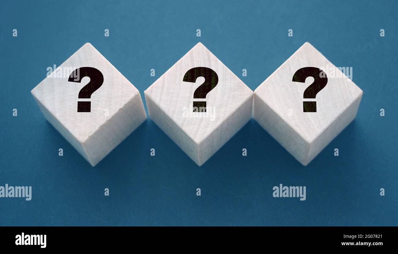 Three wooden blocks with black question marks. Faq questions and ...