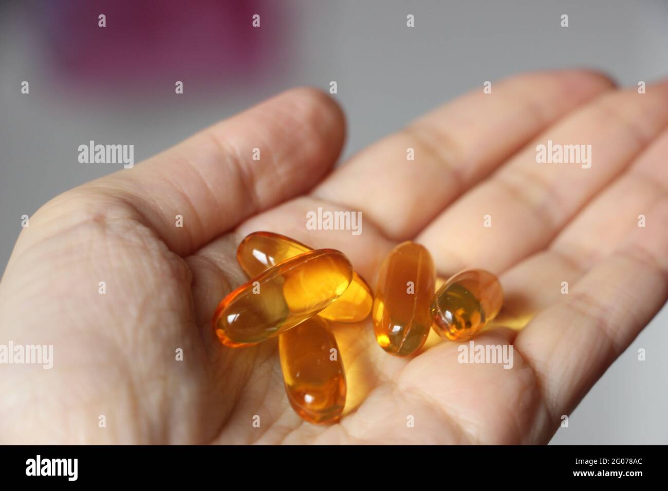 Cod liver oil capsules in hand. fish oil Omega-3 capsules. Healthcare ...