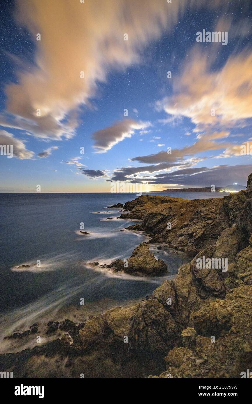 Cap Ras coastal cape, at night, with the moon rising on the horizon ...