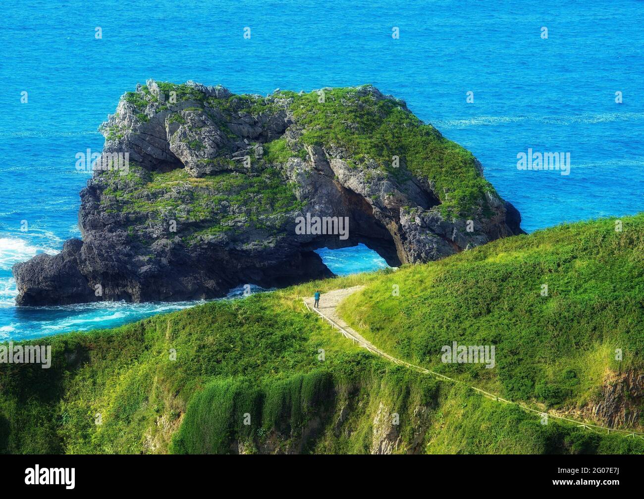 Breathtaking view of a pathway leading to the rocky island in the ocean ...
