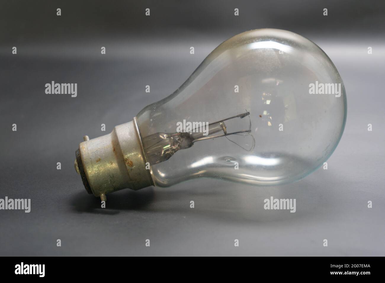 Closeup of an incandescent light bulb on a grey surface Stock Photo - Alamy