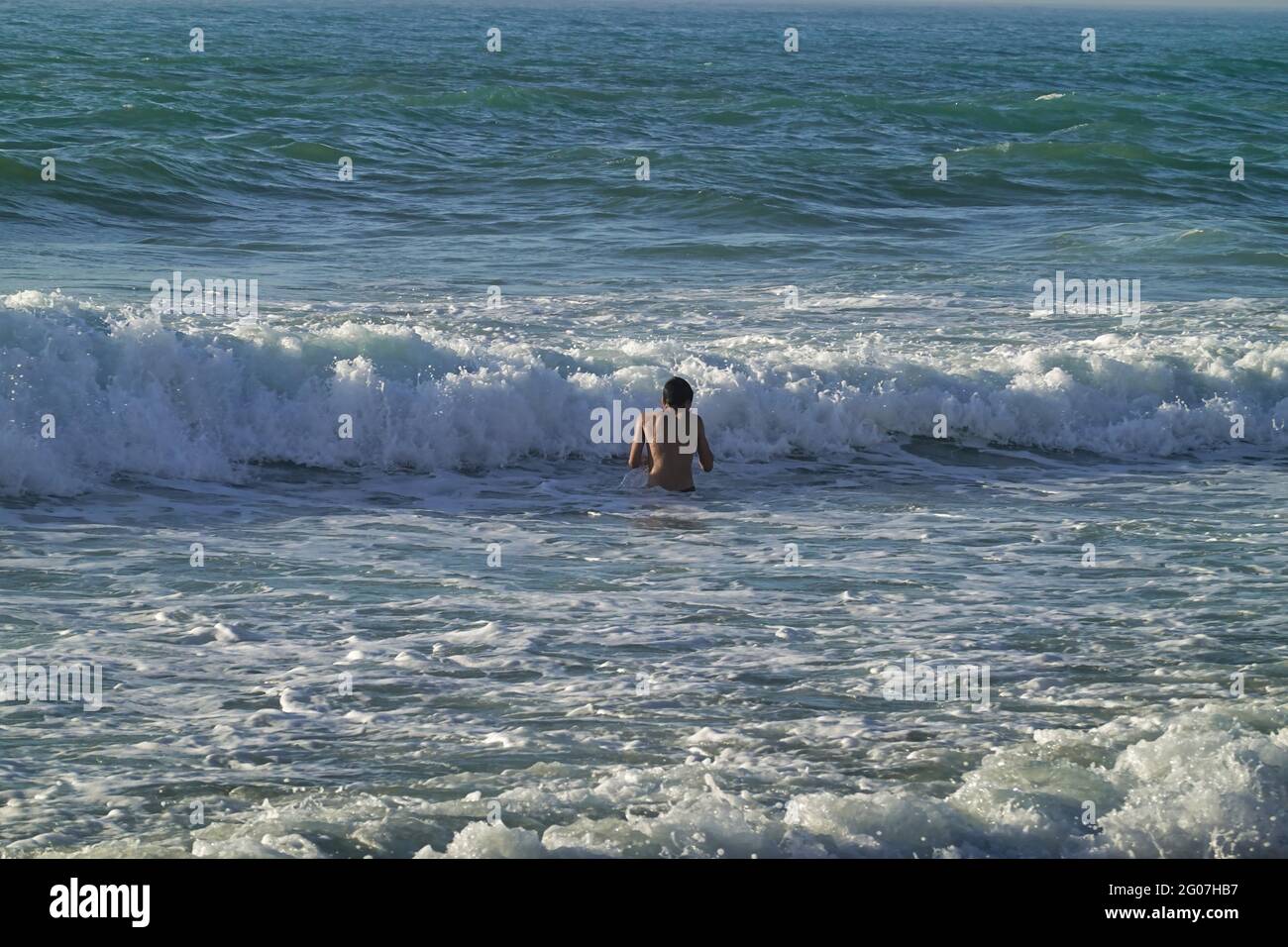 Male swimming with a seawater waves on the beach Stock Photo - Alamy