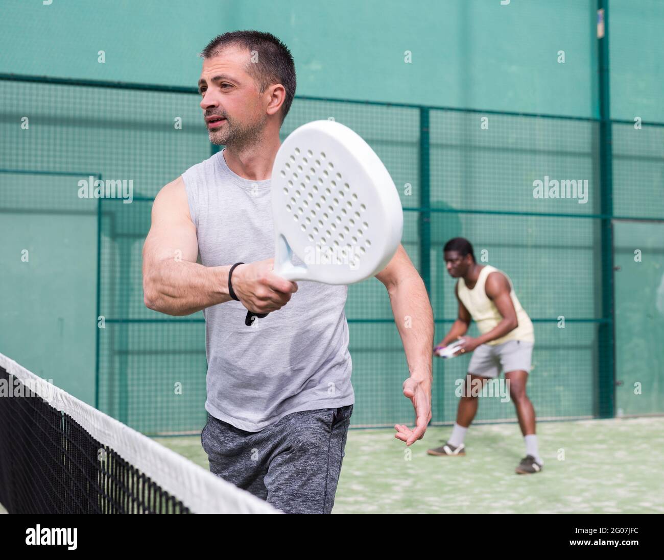 Male players playing padel in a padel court outdoor behind net Stock ...