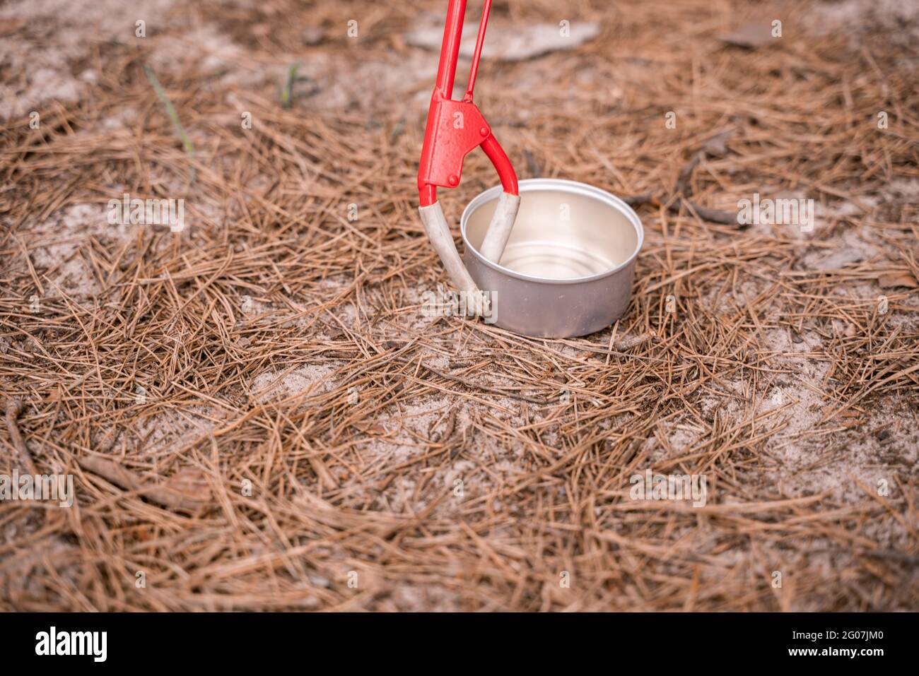 pick up tool near aluminum container on ground in woods Stock Photo - Alamy