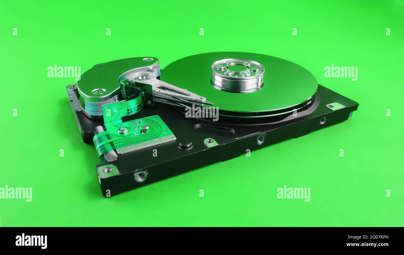 Disassembled hard drive close up with plates visible on green ...