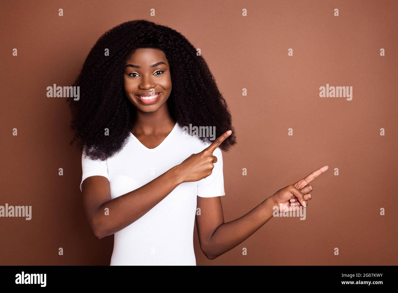 Photo portrait of curly girl smiling pointing empty space choosing ...