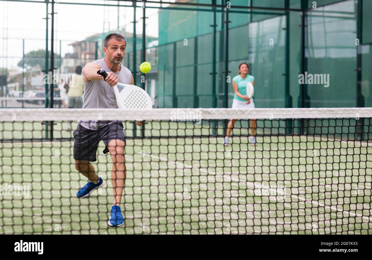 Young adult man playing paddle tennis outdoors Stock Photo - Alamy