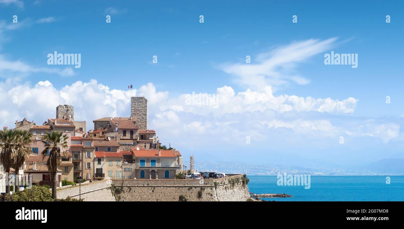 Old city of Antibes, palm trees, tower, rampart and blue mediterranean ...